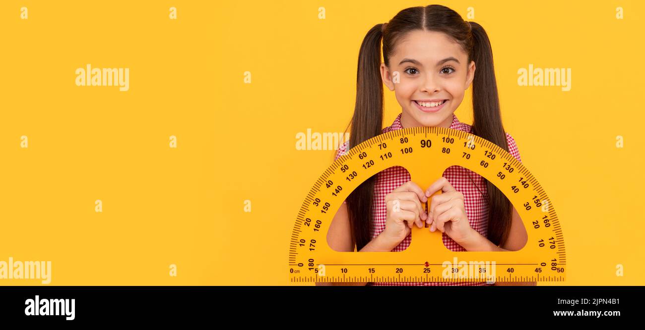 happy teen girl hold school math tool protractor ruler on yellow ...
