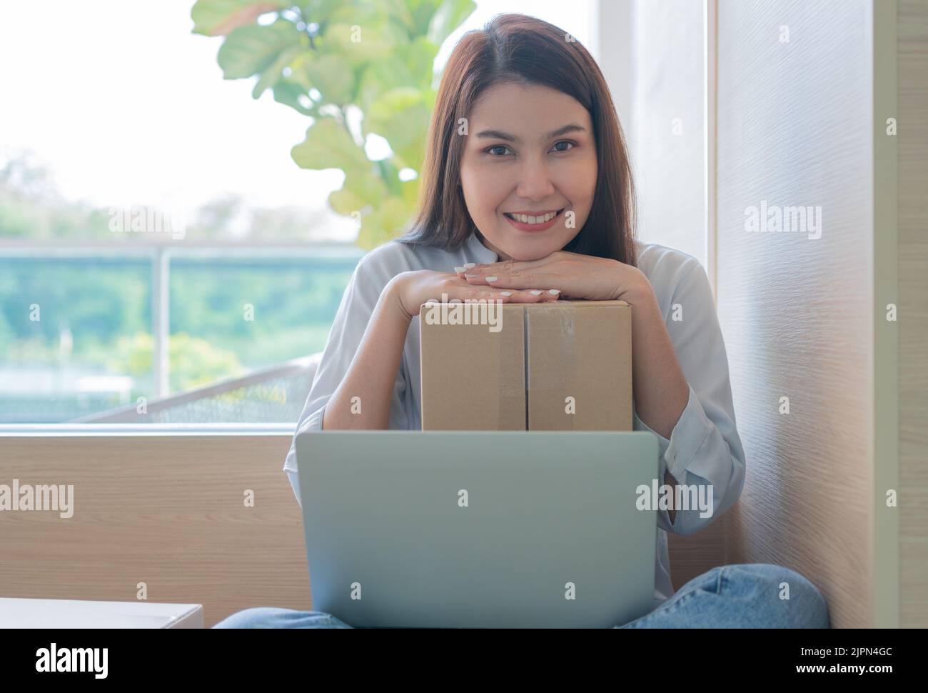 Happy young Asian woman entrepreneur, Hold package and Smile for sale ...