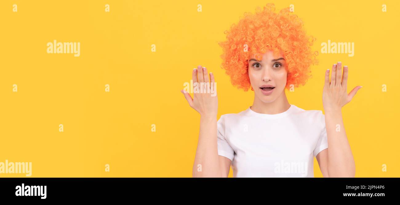 surprised freaky woman in curly clown wig with raised hands, surprise ...