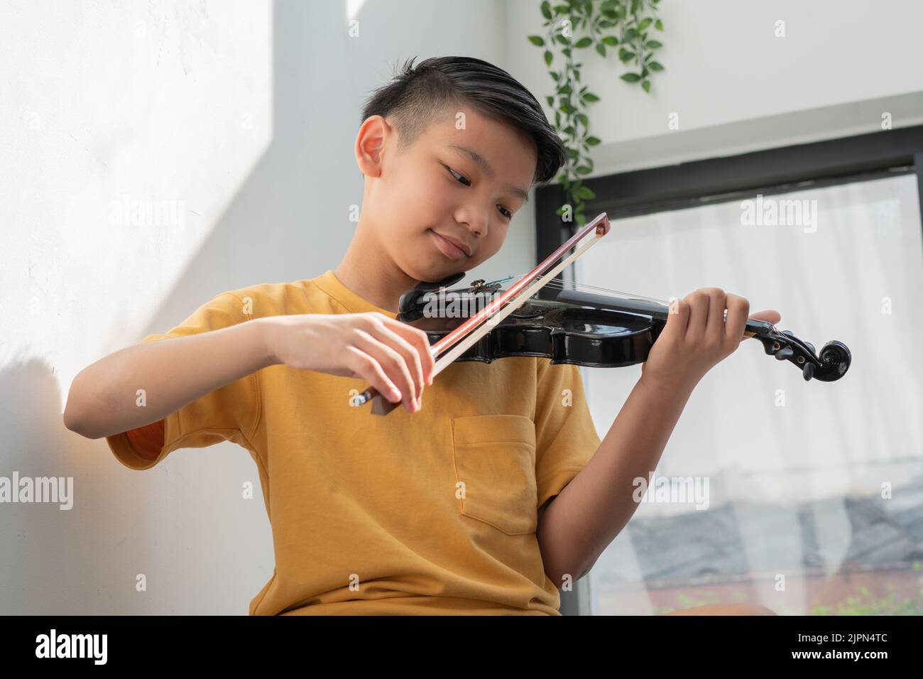 A Little Asian kid playing and practice violin musical string ...