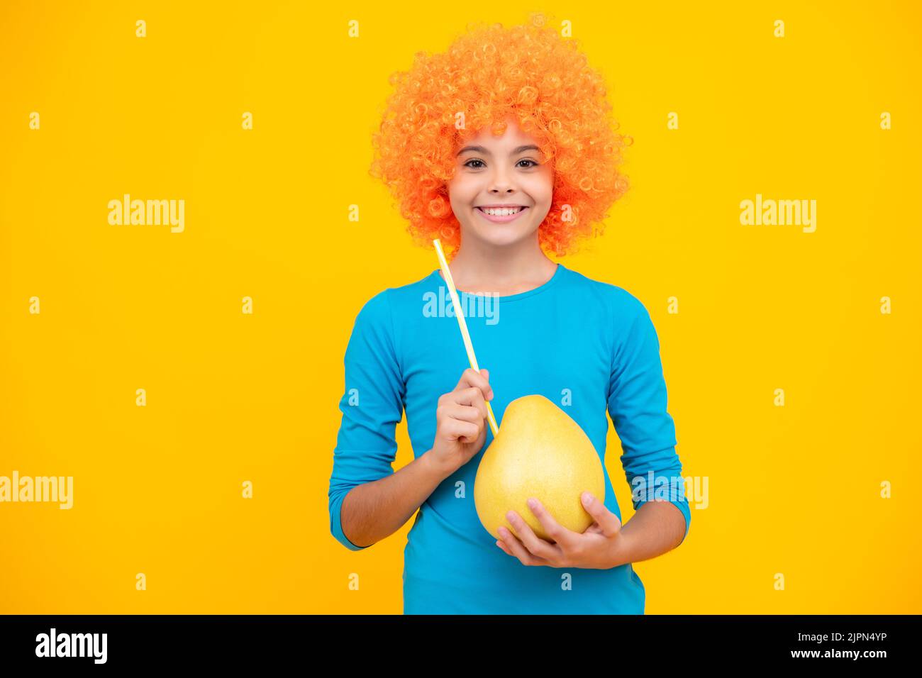 Happy teenager portrait. Funny child girl in wig hold big citrus fruit ...