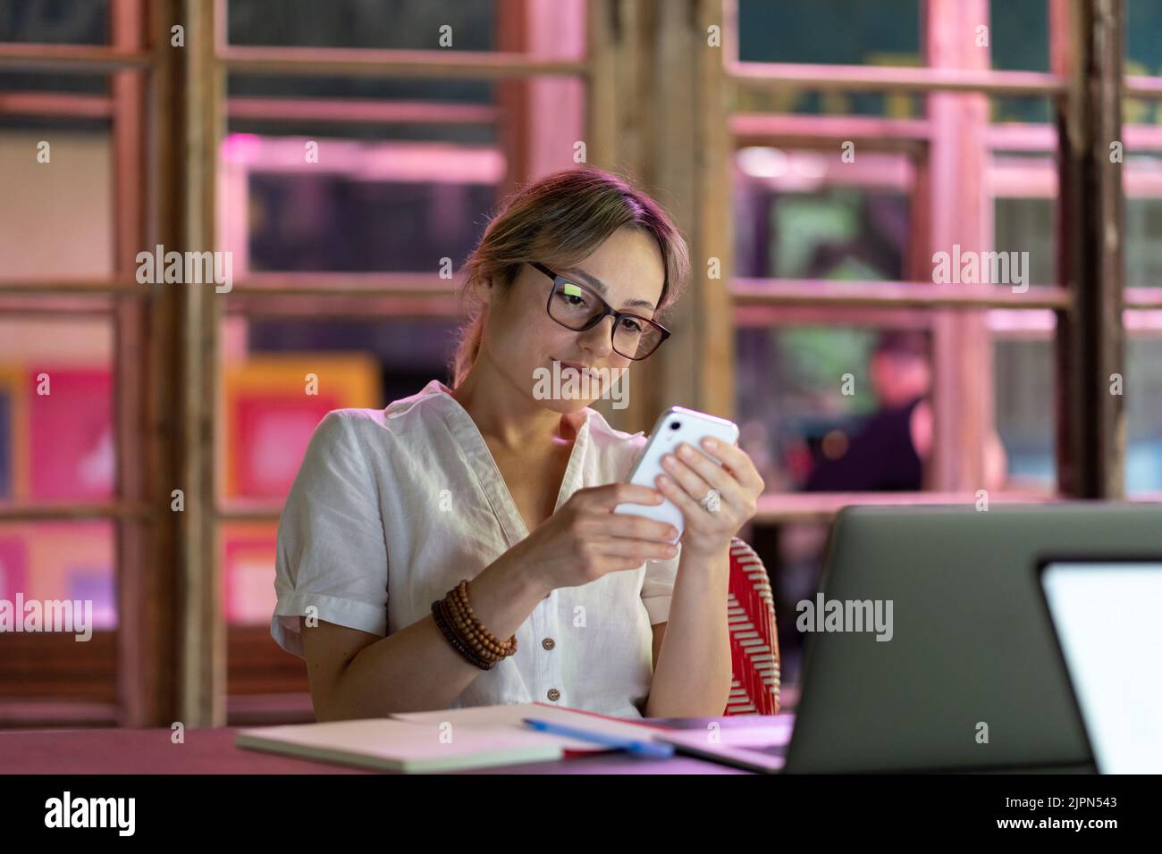 Female employee using mobile device at workplace, young woman ...