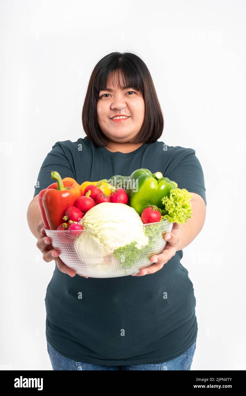 Happy Asian overweight woman holding a vegetable basket and smiling on ...