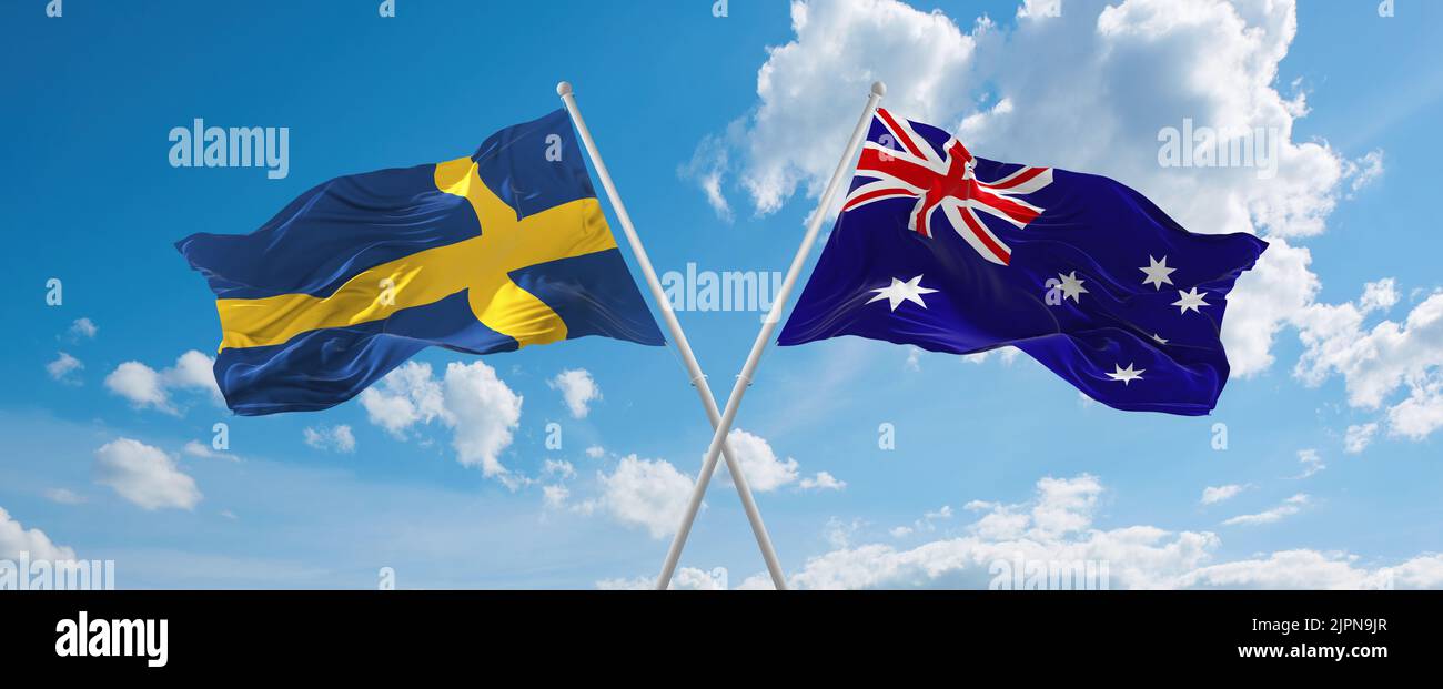 two crossed flags Australia and Sweden waving in wind at cloudy sky ...