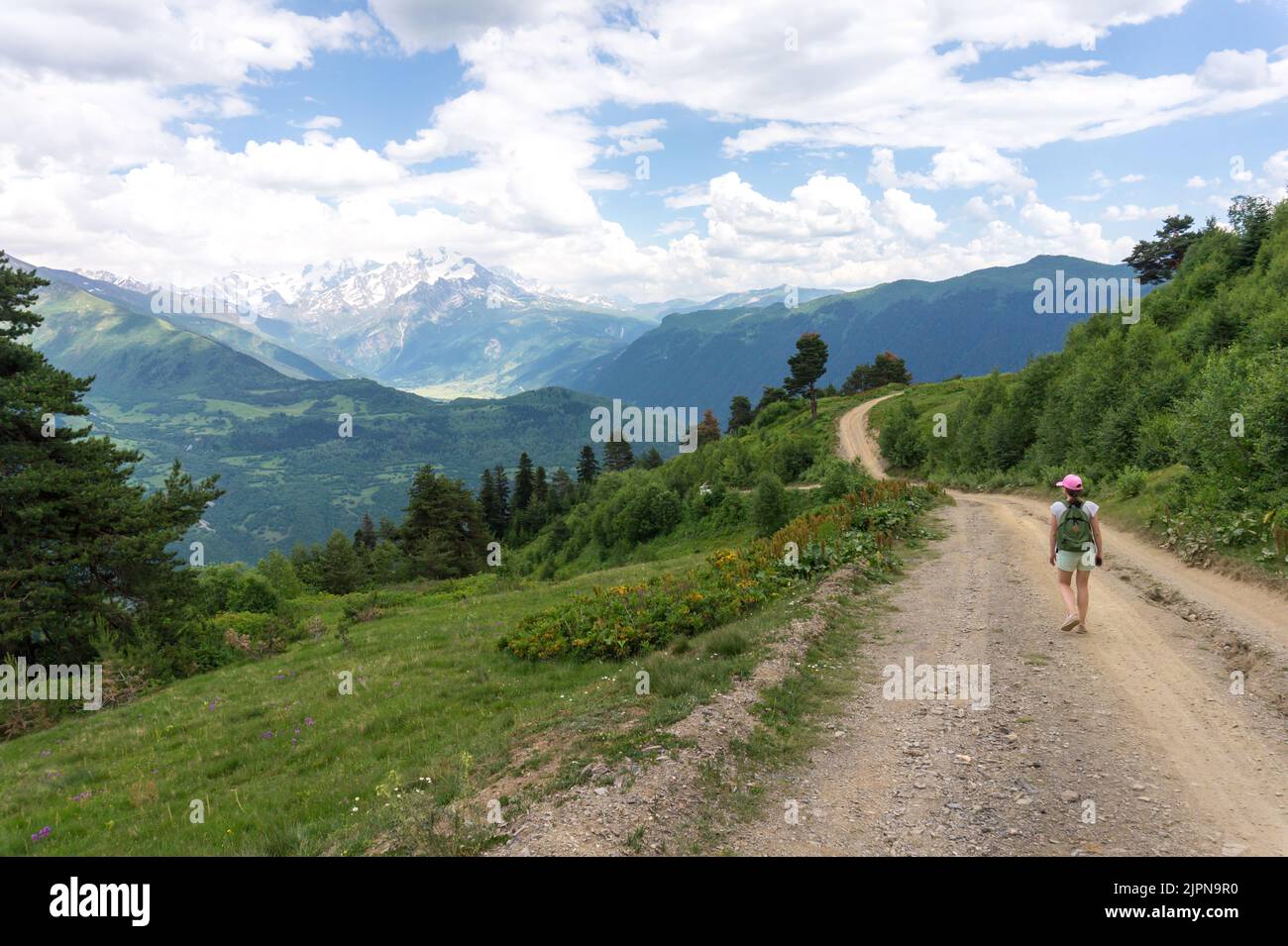 Svaneti landscape. Young tourist single traveler woman walking with a ...