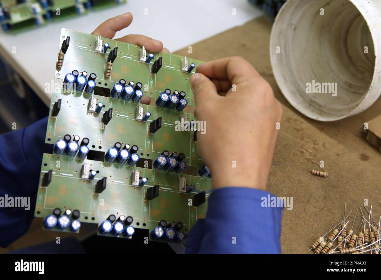 A man collects a printed circuit board. The worker solders the radio ...