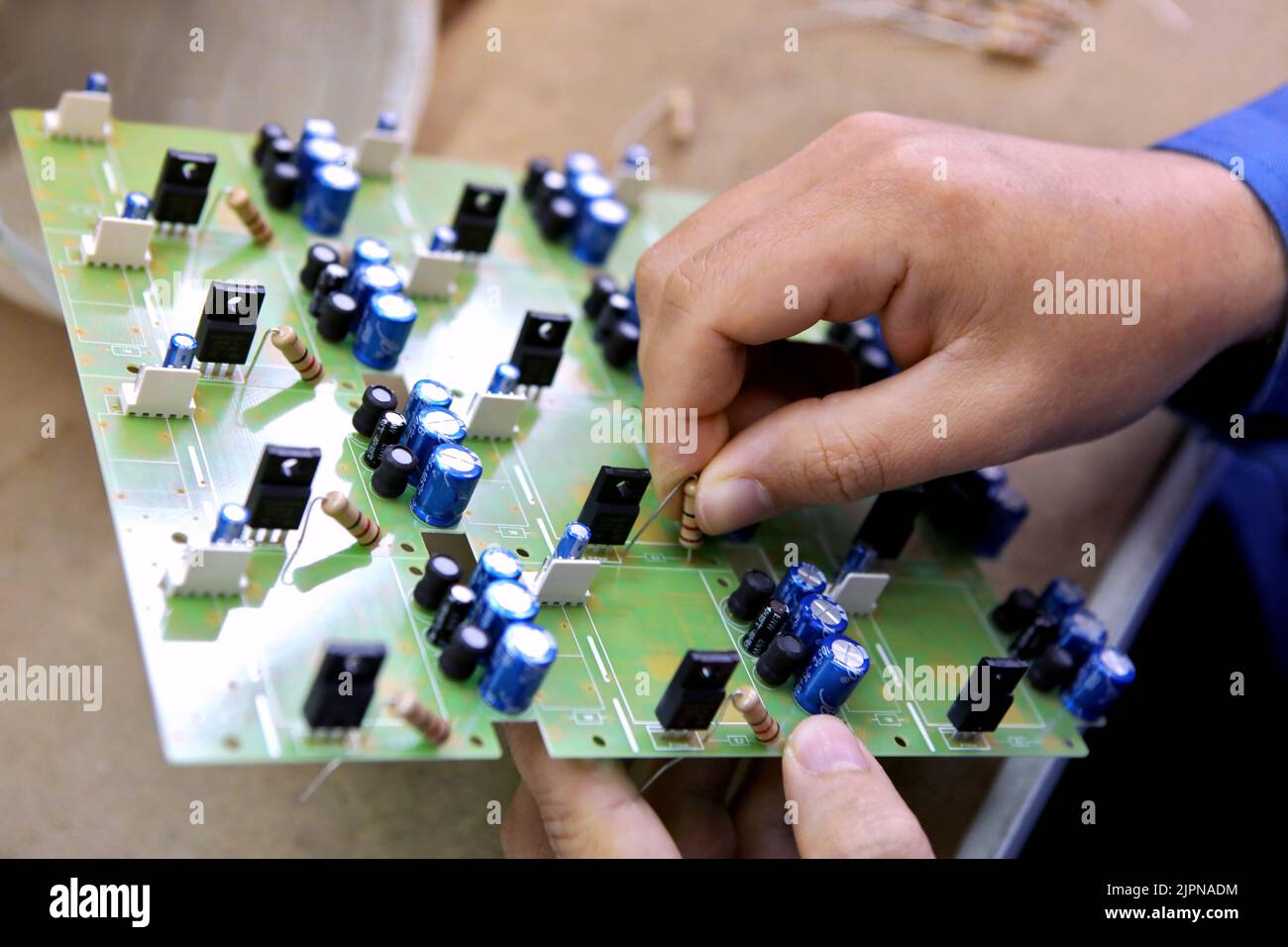 A man collects a printed circuit board. The worker solders the radio components and assembles ...
