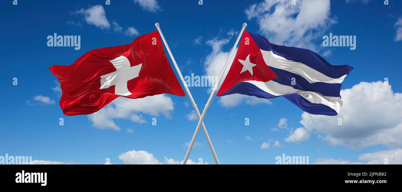 two crossed flags Cuba and Switzerland waving in wind at cloudy sky ...