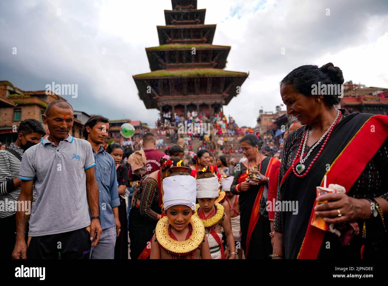 Young devotees with lit oil lamps on their heads and shoulders take ...