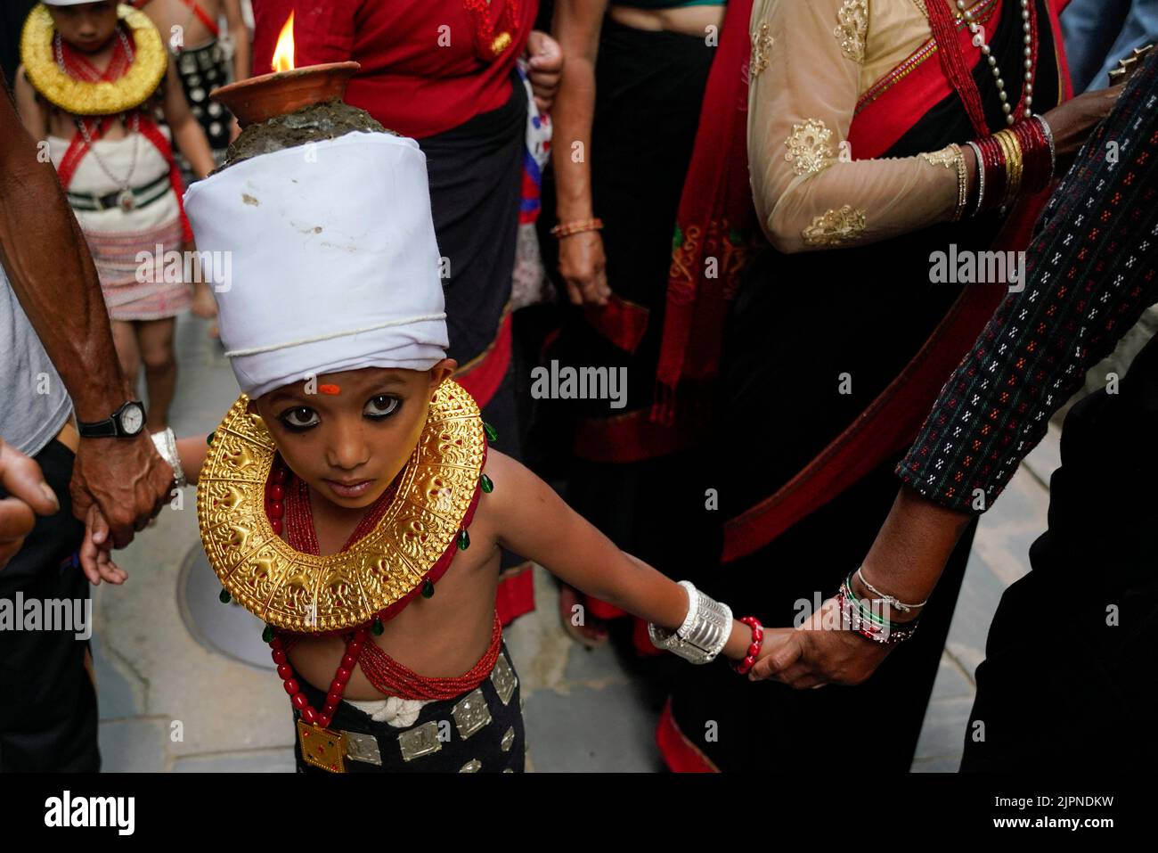A young devotee with lit oil lamps on his head and shoulders takes part ...