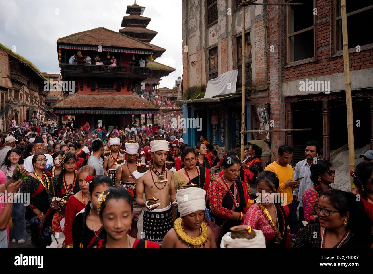 Young devotees with lit oil lamps on their heads and shoulders take ...