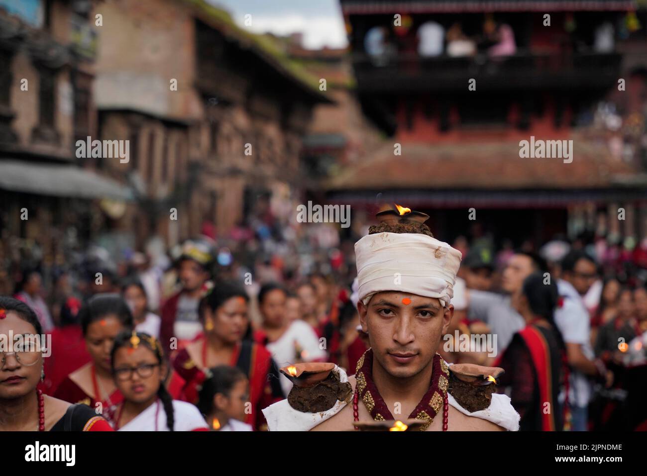 A devotee with lit oil lamps on his head and shoulders takes part in a ...