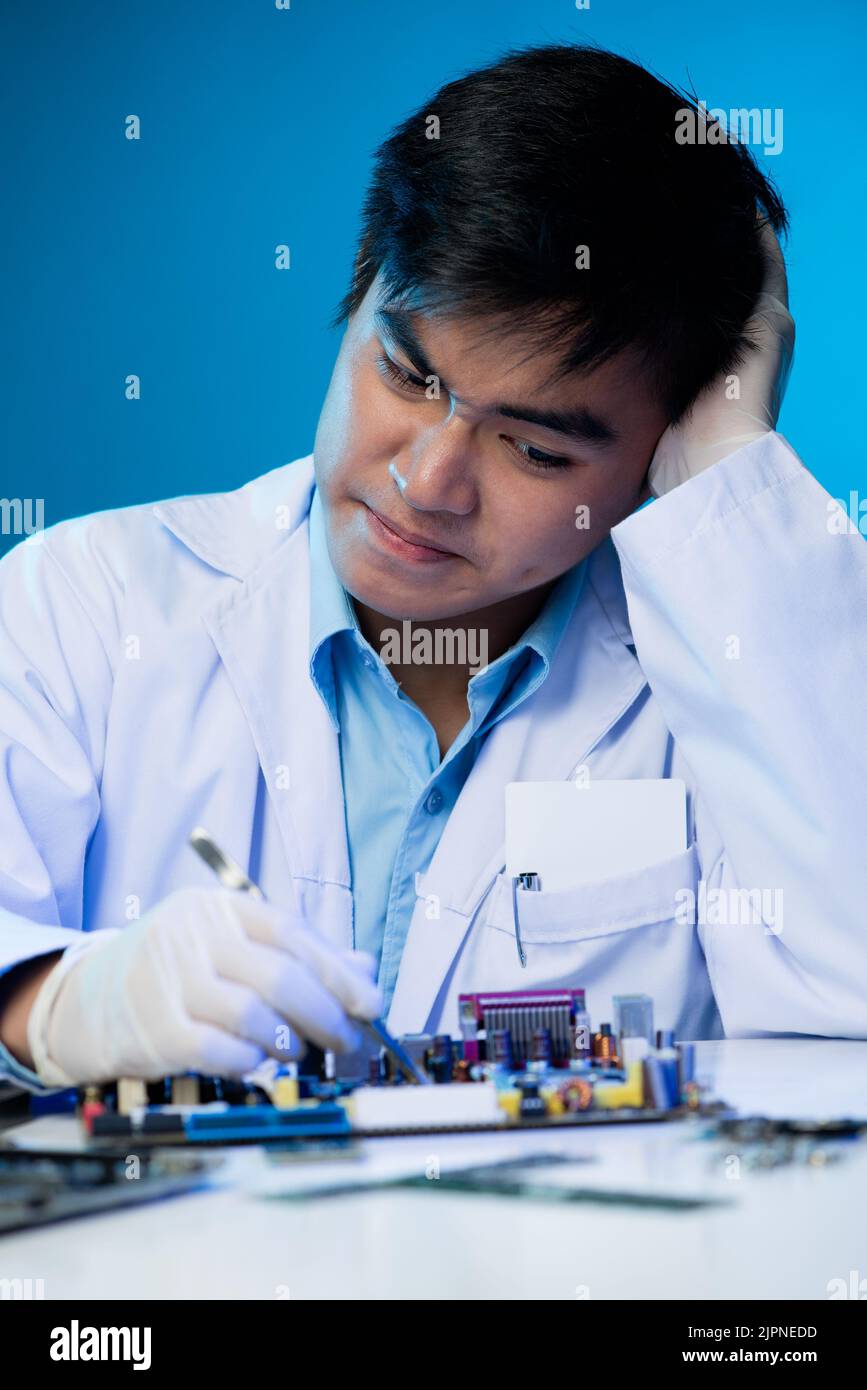 Sad irritated professional engineer working with circuit board Stock ...