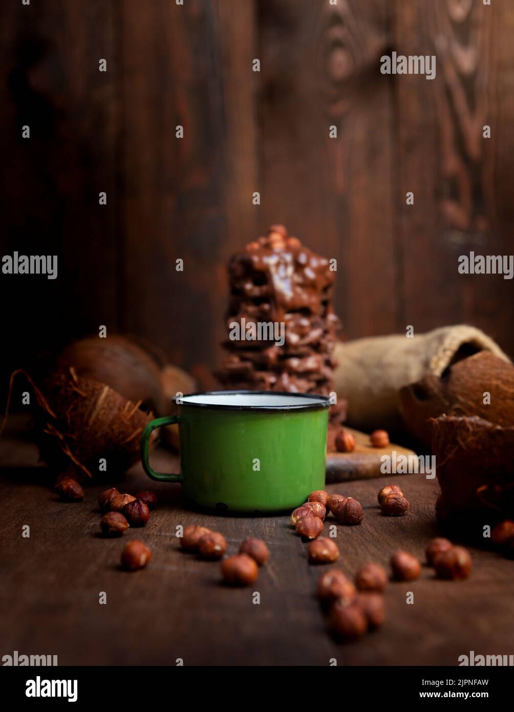 Hot chocolate in the mug with hazelnuts and stack of chocolate bars in ...