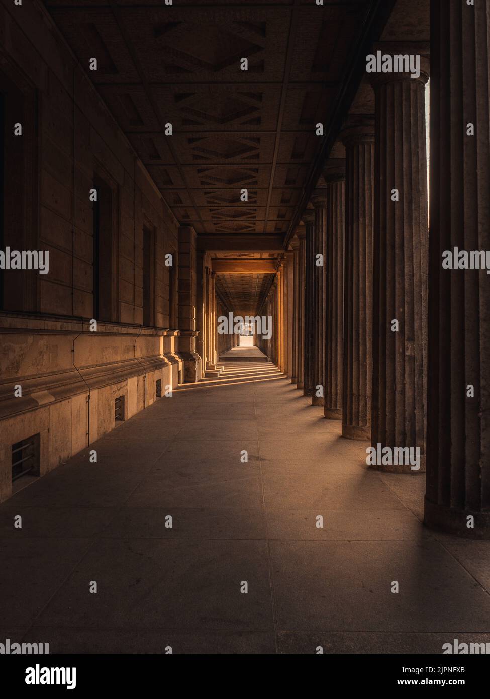 A vertical shot of an empty concrete walkway with columns Stock Photo ...