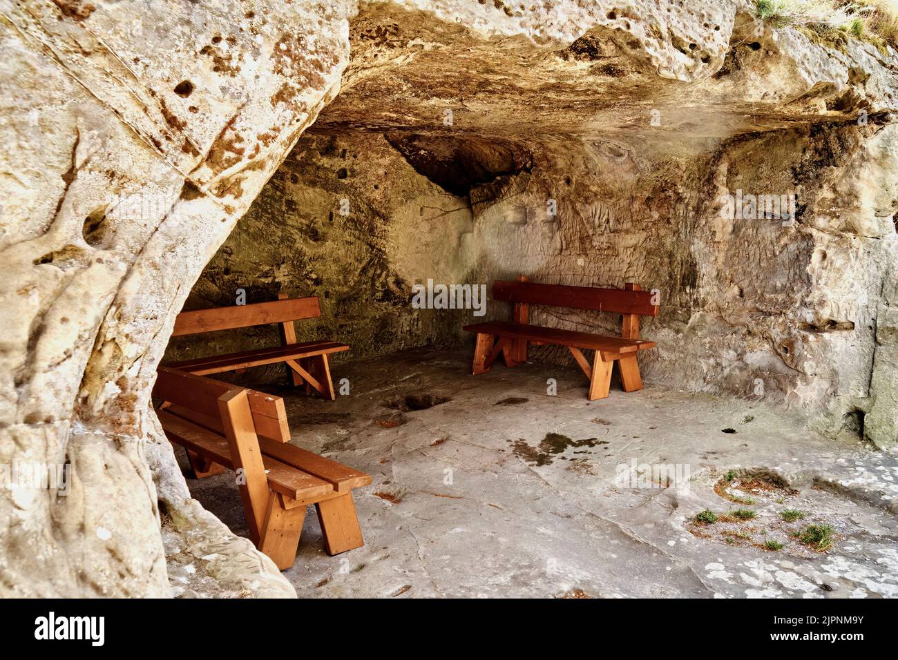 Dry protected resting benches for hikers in a small cave in the ...