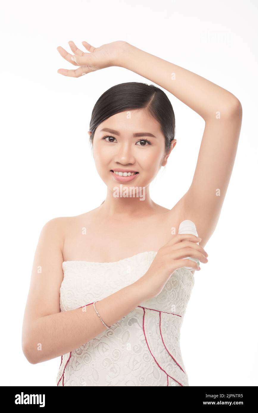 Smiling pretty young Asian woman applying deodorant Stock Photo - Alamy