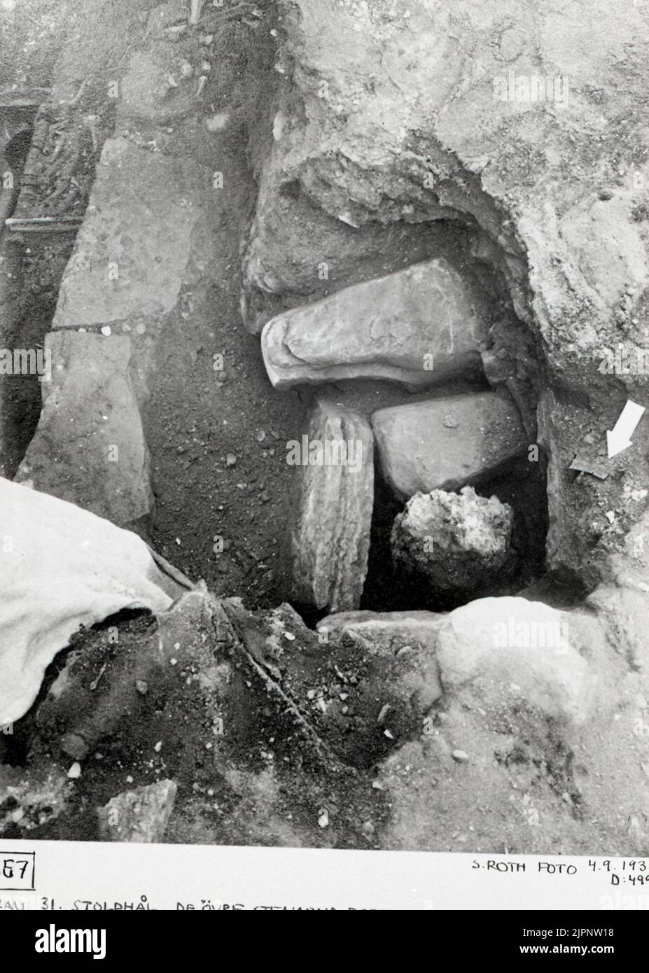 Grave 31. post holes. The upper stones removed. At the arrow KAM 1936: ...