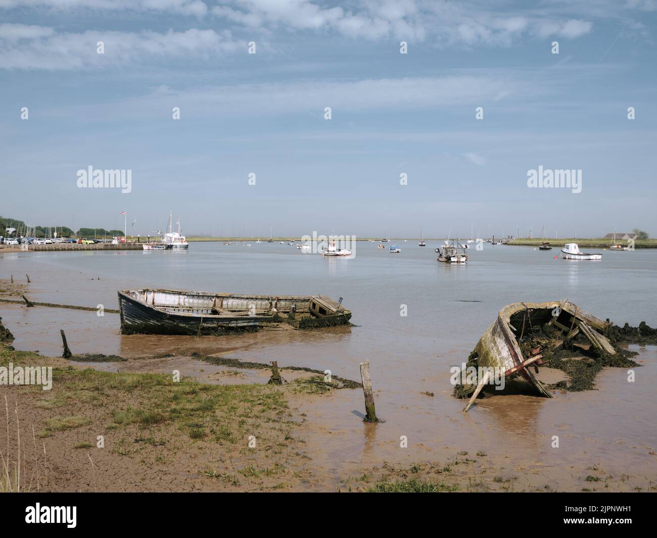 The summer tidal coastal landscape with abandoned boats at Orford ...