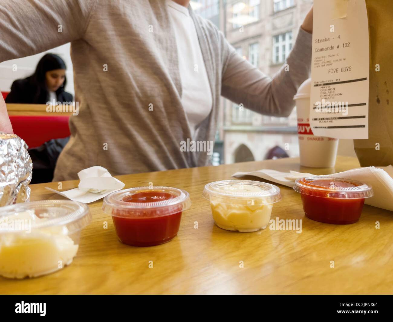 Paris, France - Feb 4, 2022: Woman at the iconic Five Guys hamburger ...