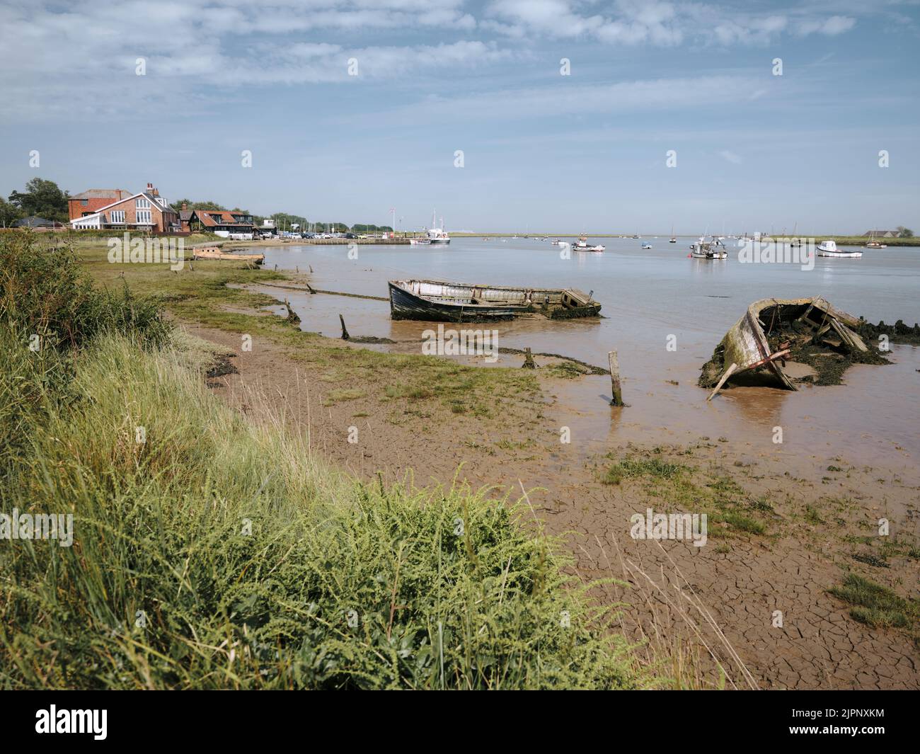 The summer tidal coastal landscape with abandoned boats at Orford ...