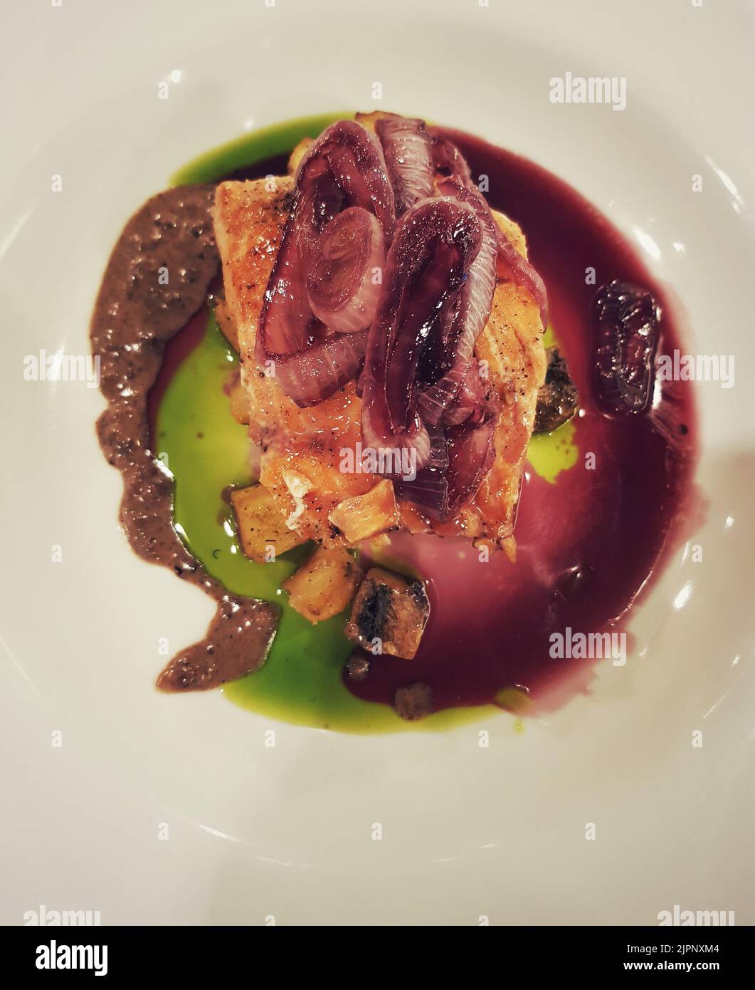 A top view of a dinner with fried onion potato cubes and meat on top of ...