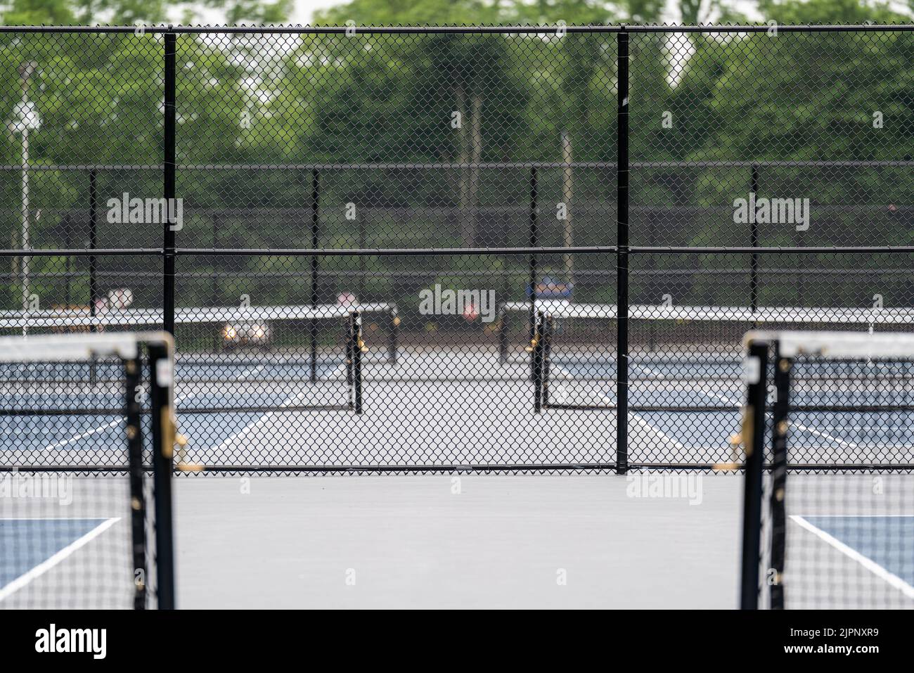 View between three sets of new blue tennis court with white lines and ...