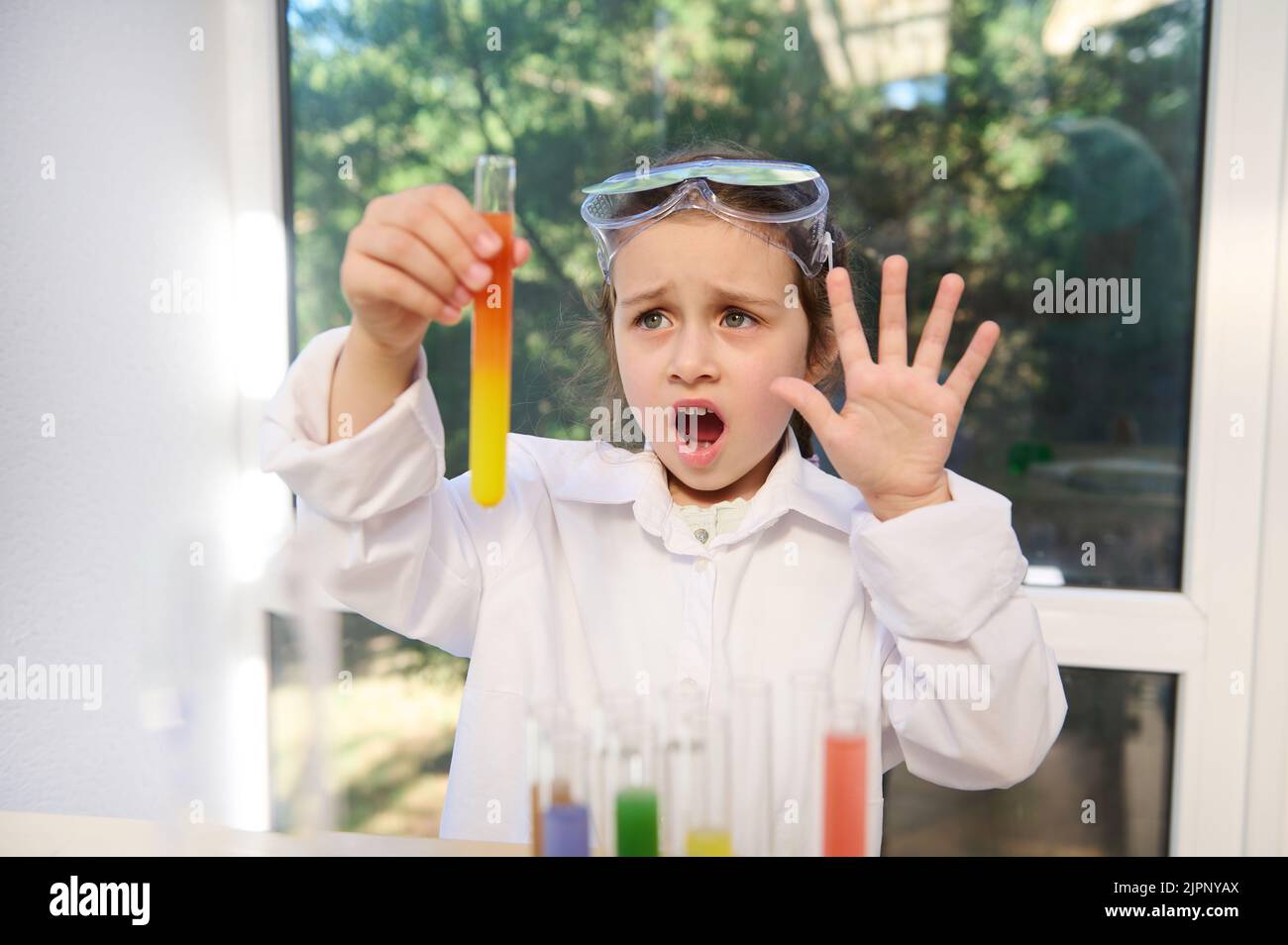 Excited little girl, child chemist with enthusiasm and excitement ...