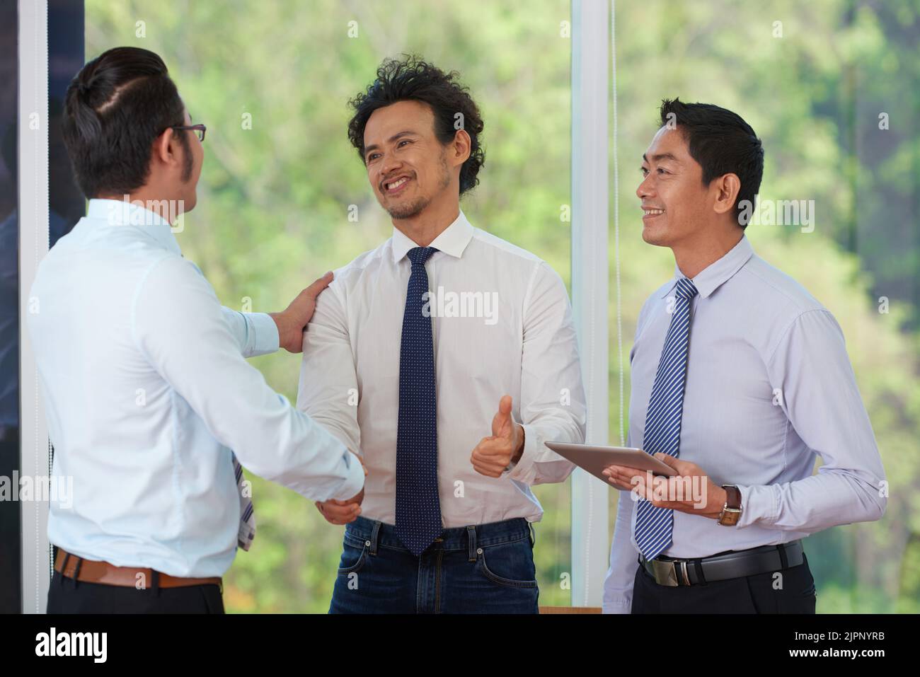 Businessman congratulating his happy coworker Stock Photo - Alamy