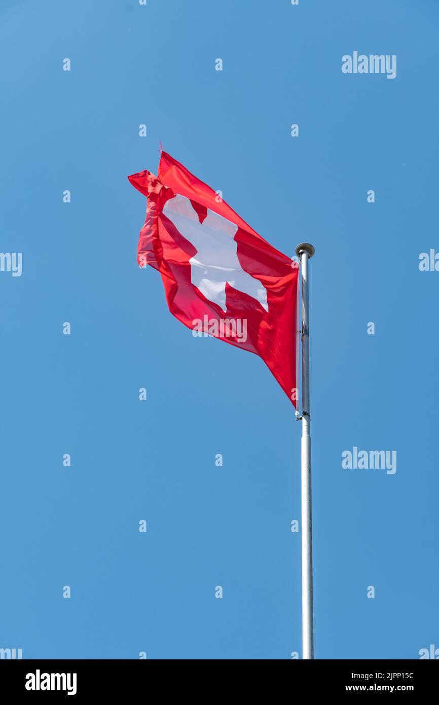 Truebbach, Switzerland, April 28, 2022 Swiss national flag is waving in ...