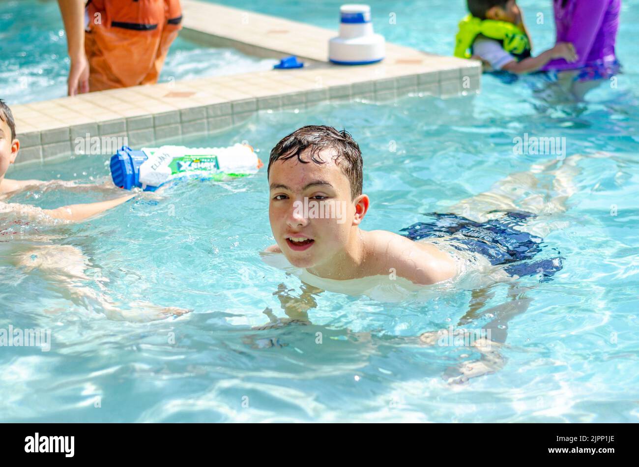 A teenage boy relaxes in a swimming pool Stock Photo - Alamy
