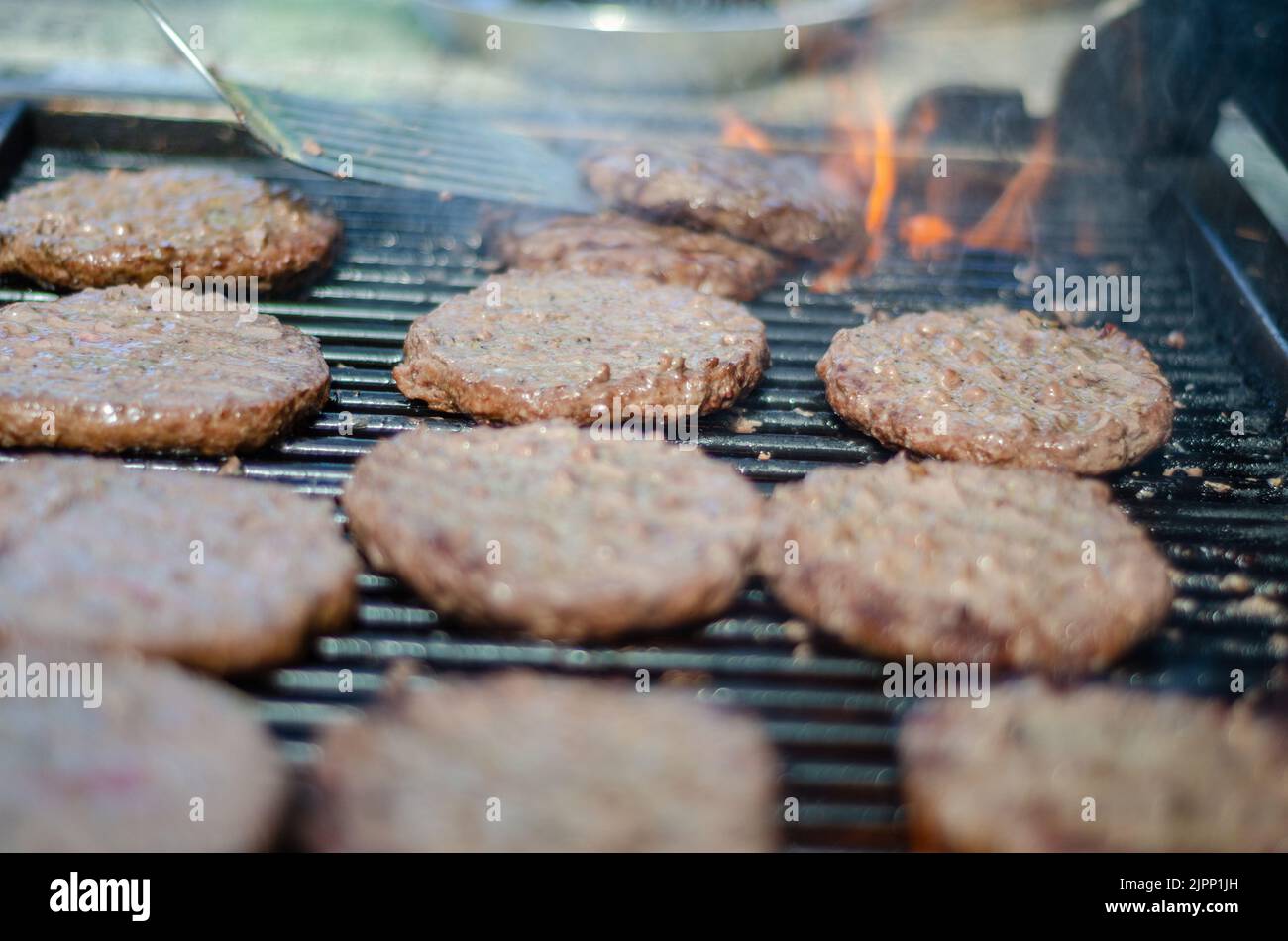 Beef burgers cooking on a barbecue Stock Photo - Alamy