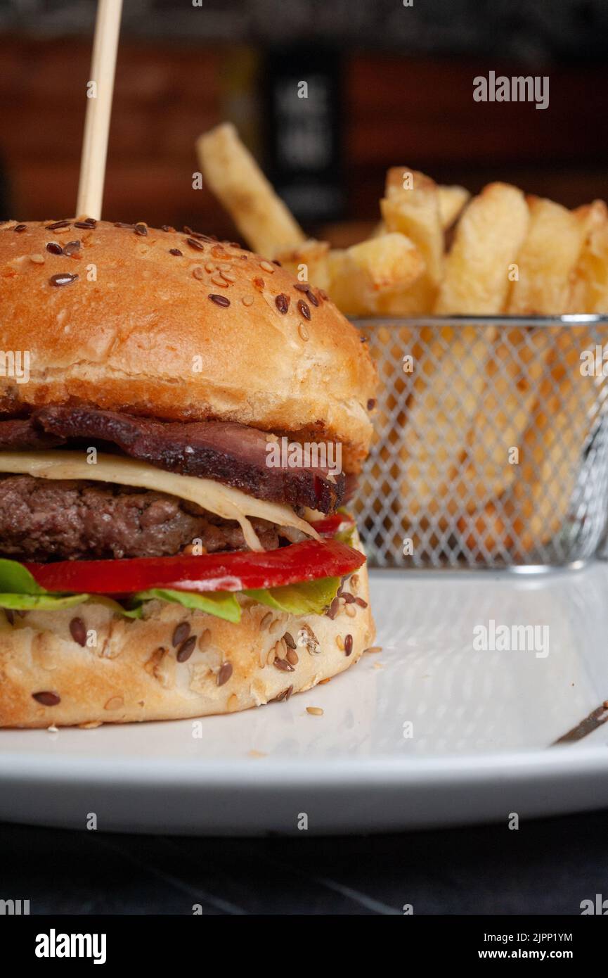 A vertical closeup shot of a testy burger with french fries in a fast ...