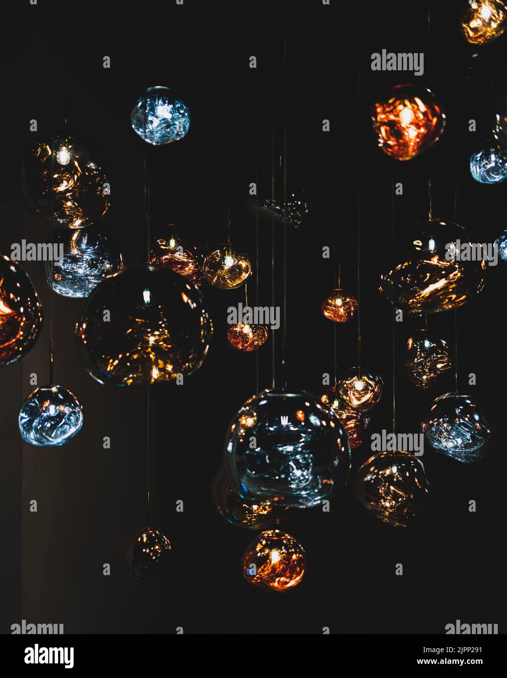 A vertical closeup shot of lighted colorful glass lamps hanging from ...