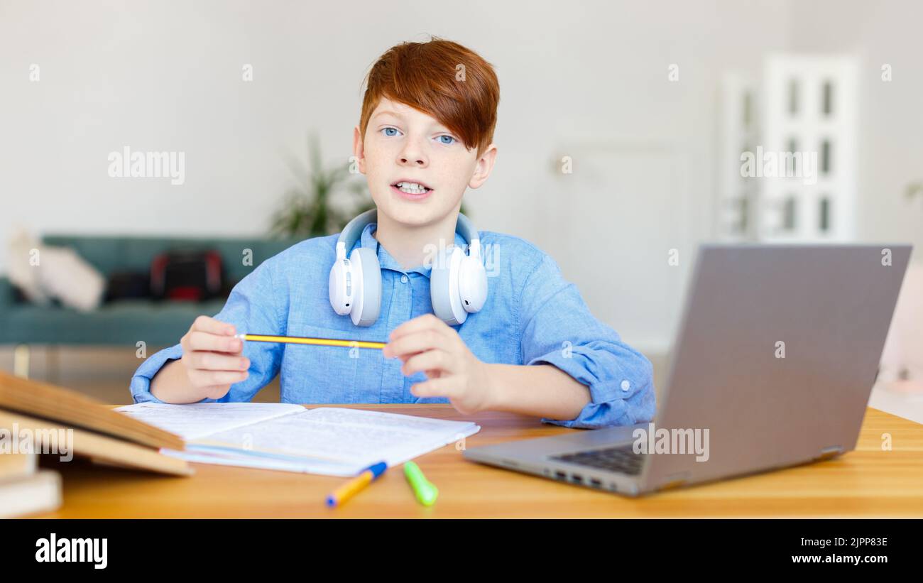 A schoolboy during an online seminar. He makes a presentation on his ...