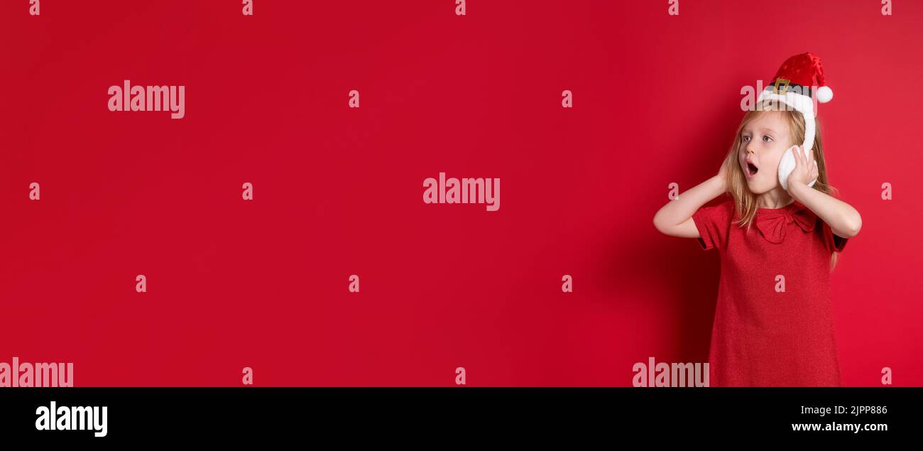 Long banner. girl in christmas clothes, surprise and laugh on a red ...