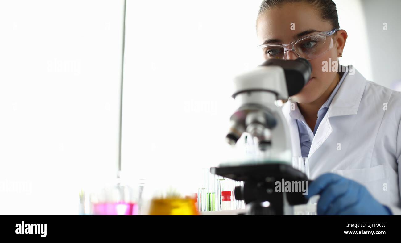 Young woman scientist looks into microscope in laboratory Stock Photo ...