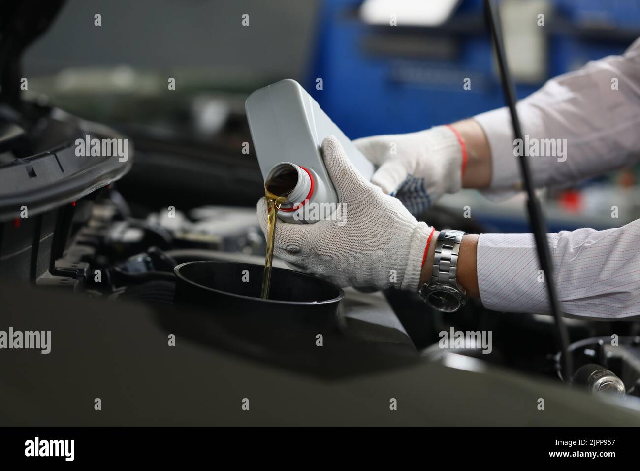 Mechanical filling of oil into car in repair garage Stock Photo - Alamy