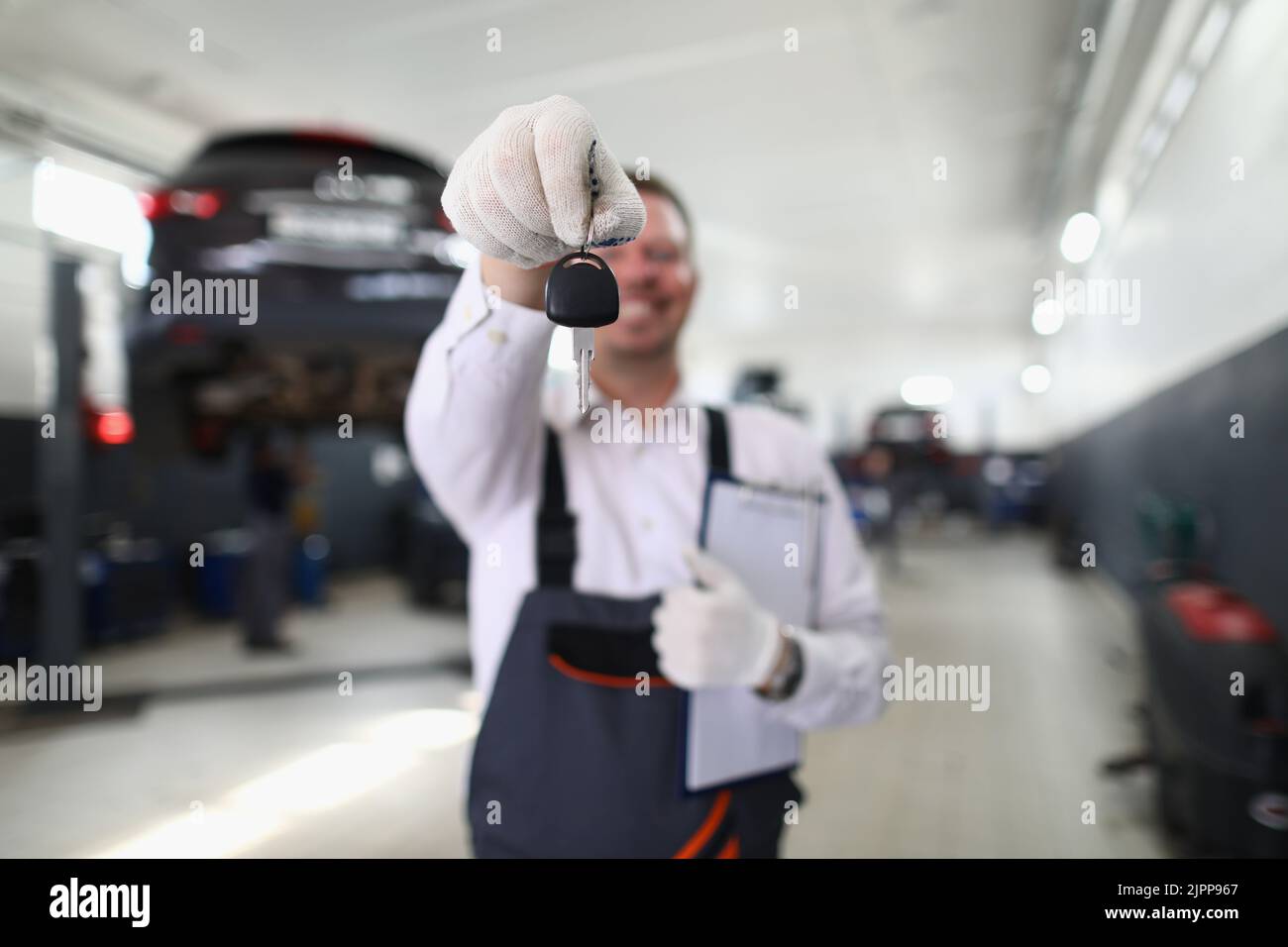 Auto mechanic holds clipboard and car keys Stock Photo - Alamy