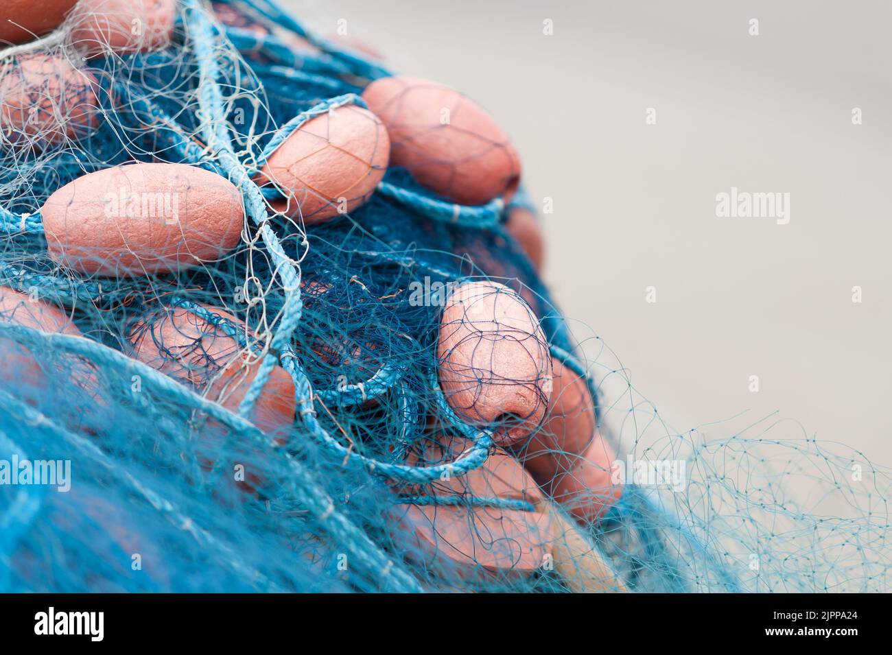A closeup of a blue fishing net with red floats Stock Photo - Alamy