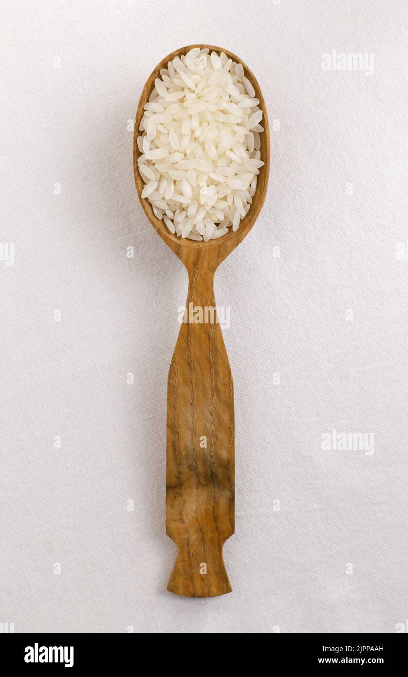 Dry camolino rice in a wooden spoon on a white background. The concept ...