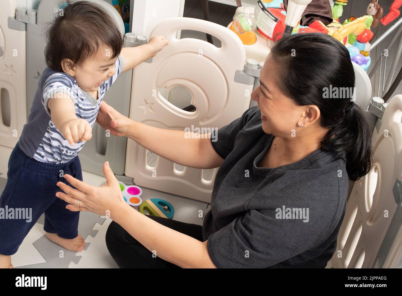 11 month old baby boy at home taking first steps toward mother, excited, happy, proud Stock ...