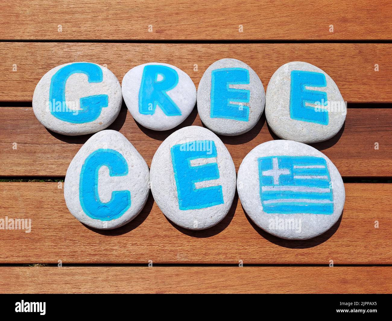 Greece country name painted on the stones on wooden plank background ...