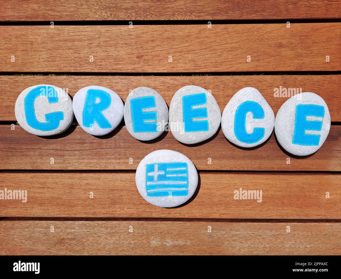 Greece country name painted on the stones on wooden plank background ...