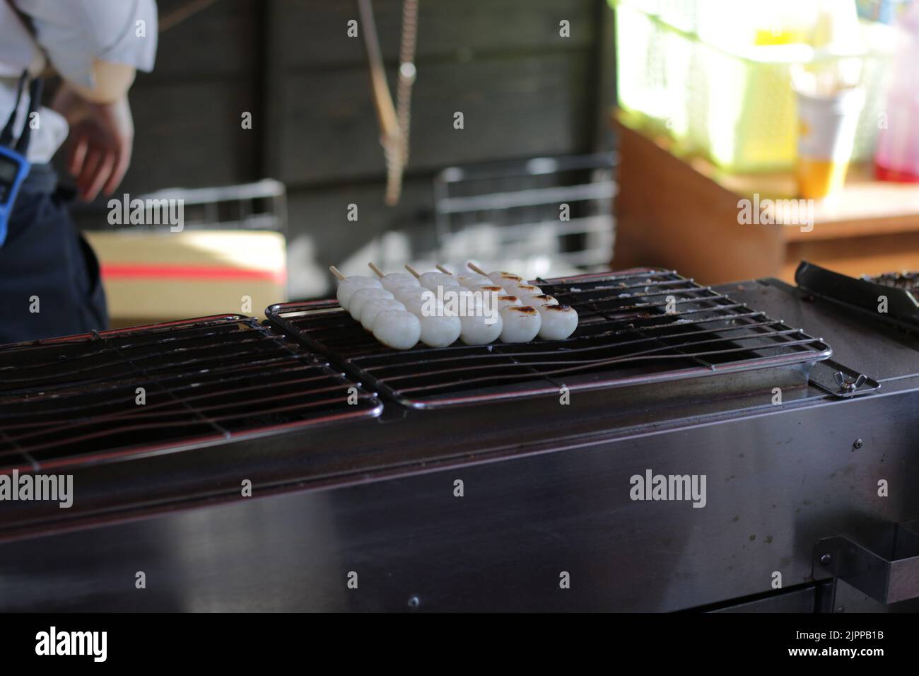 Famous Japanese sweet rice dumplings on sticks being grilled Stock ...