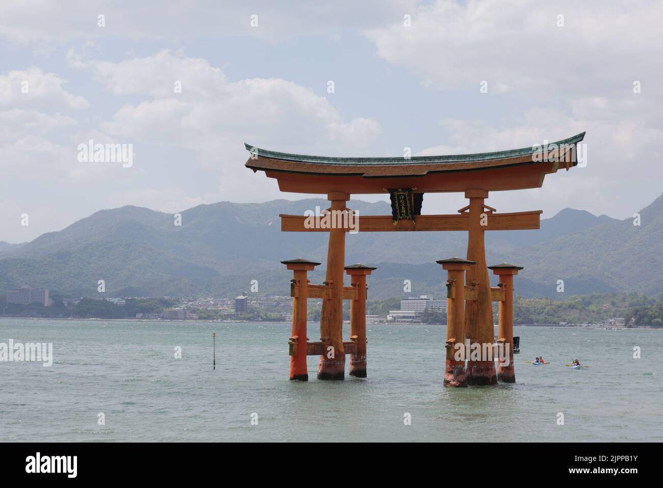 An old Japanese torii gate in the middle of a sea against a blue sky in ...