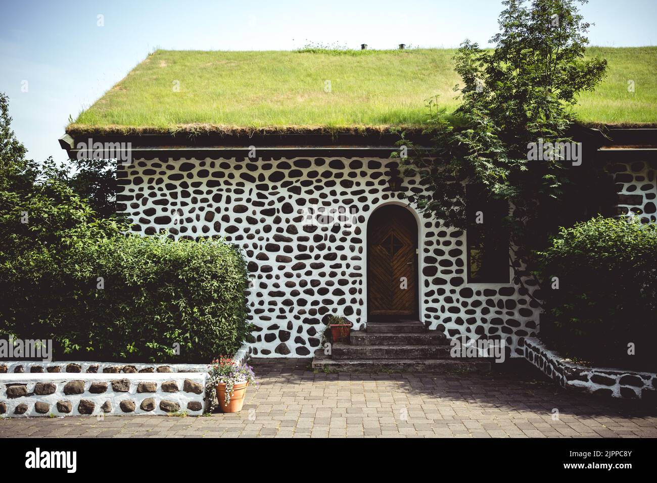 A closeup shot of a stone wall house and the grass-covered roof Stock ...