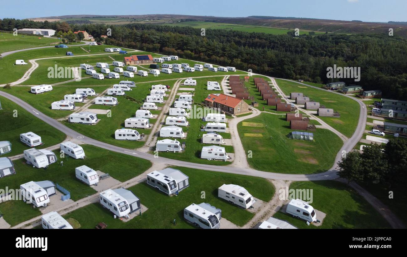 Aerial view of caravans on forest campsite with two houses in the lines ...