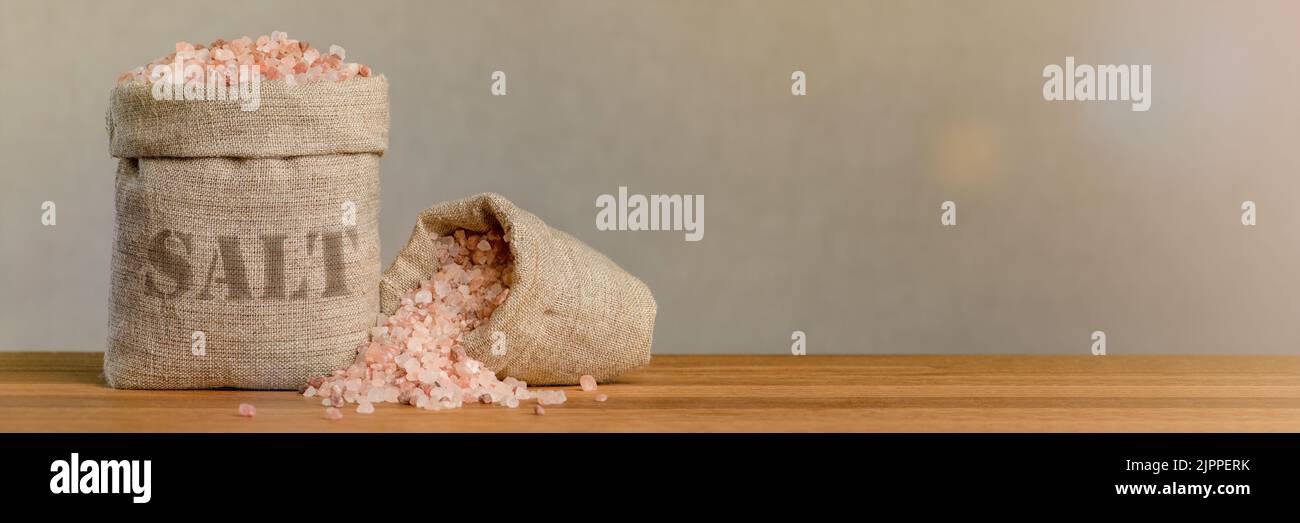 Salt price. Large crystals of pink Himalayan salt, close-up. A coin in ...