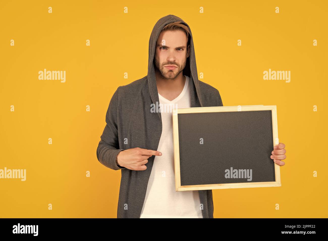 man presenting advertisement with copy space on yellow background ...